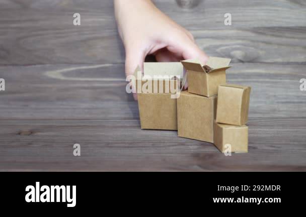 Hand takes small open boxes while coffee beans and empties them on a ...