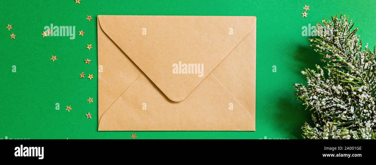 paper envelope, christmas tree branches on green background with ...
