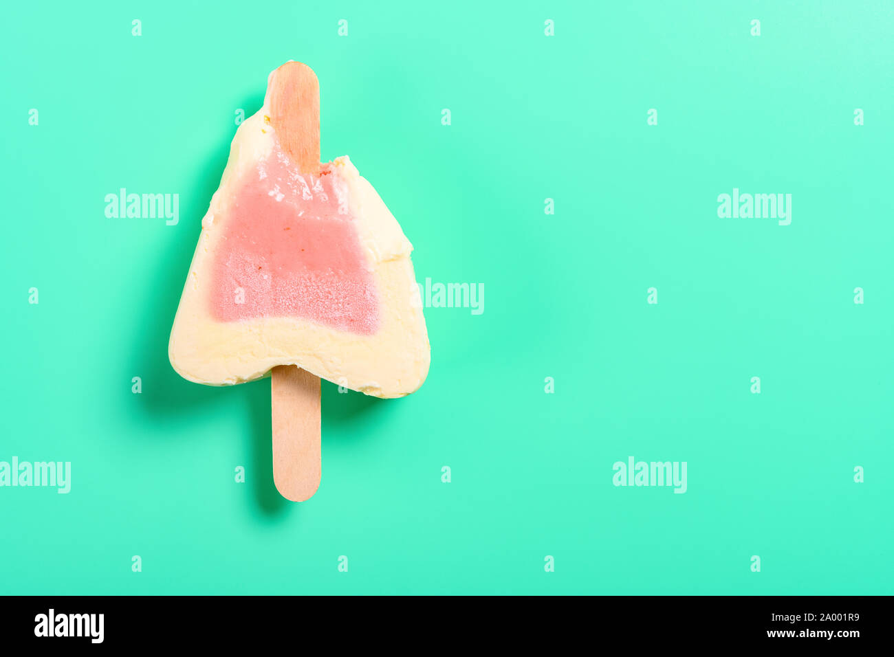 top view strawberry flavor popsicle with some bites on a green ...