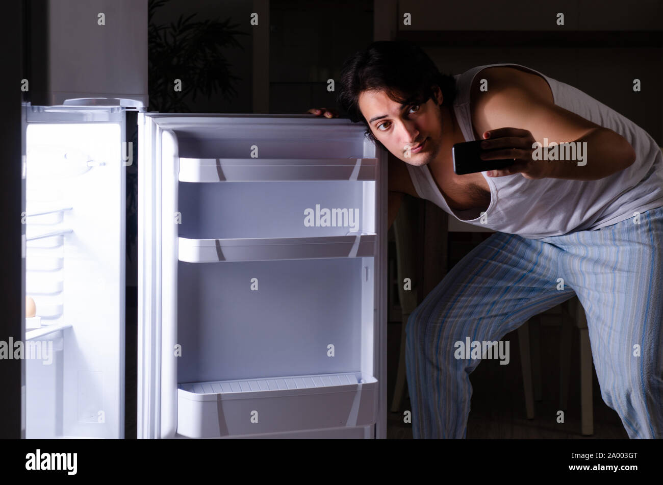 Young man fridge opening night hi-res stock photography and images - Alamy