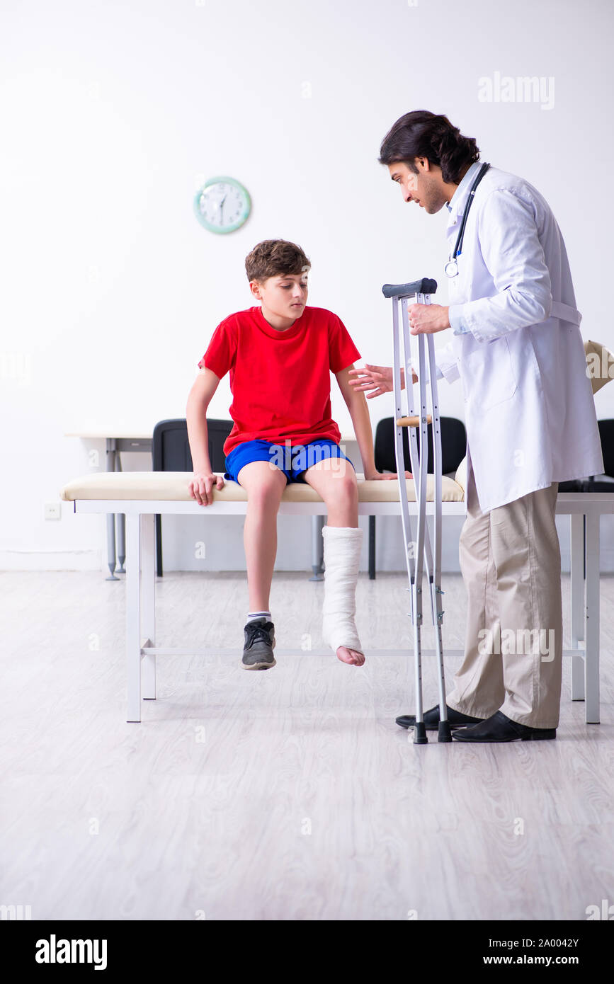The leg injured boy visiting young doctor traumatologist Stock Photo ...