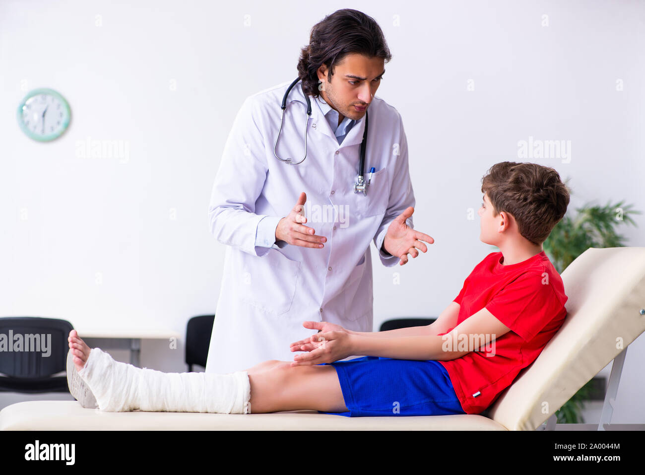 The leg injured boy visiting young doctor traumatologist Stock Photo ...