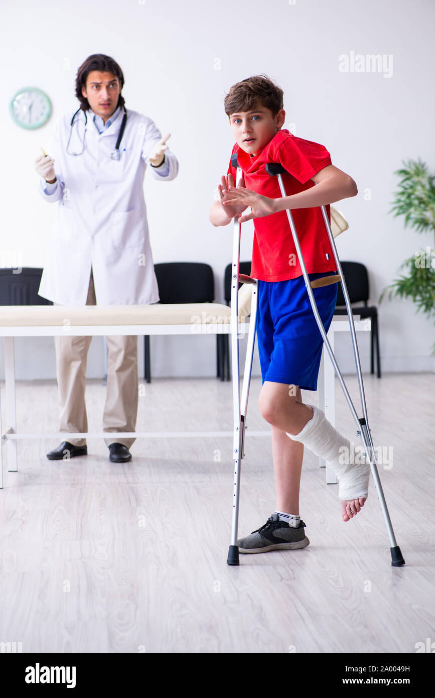 The leg injured boy visiting young doctor traumatologist Stock Photo ...