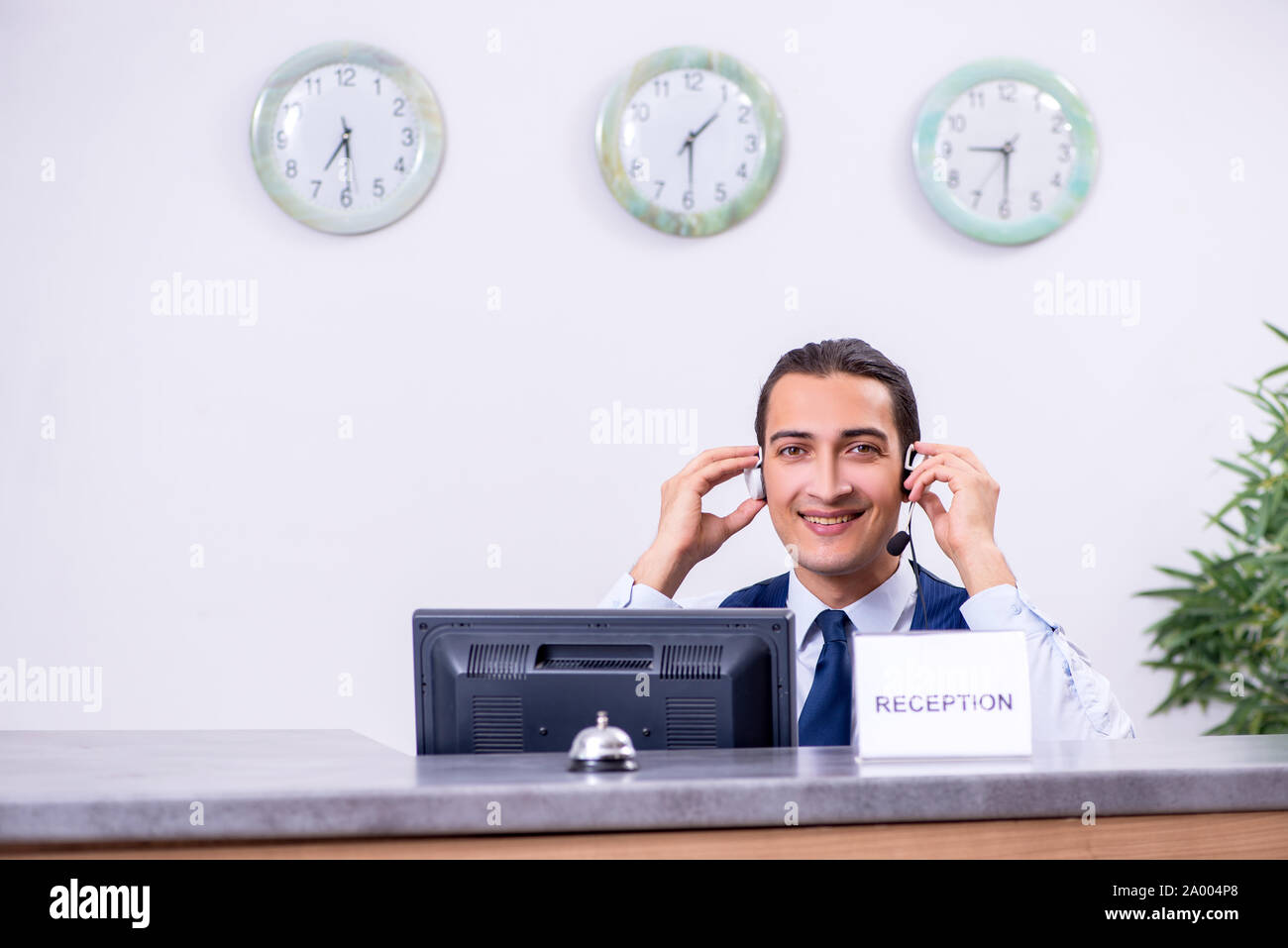 The young man receptionist at the hotel counter Stock Photo - Alamy