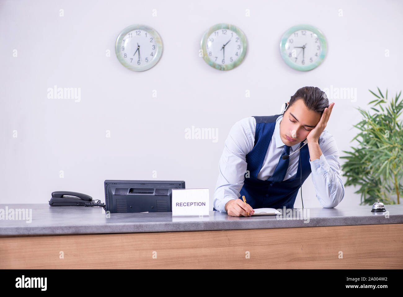 The young man receptionist at the hotel counter Stock Photo - Alamy