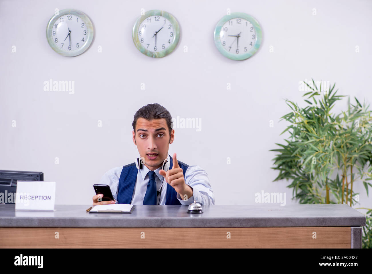 The young man receptionist at the hotel counter Stock Photo - Alamy