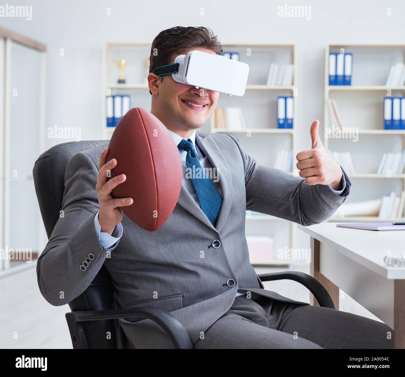 Businessman playing virtual reality football in office with VR goggle ...
