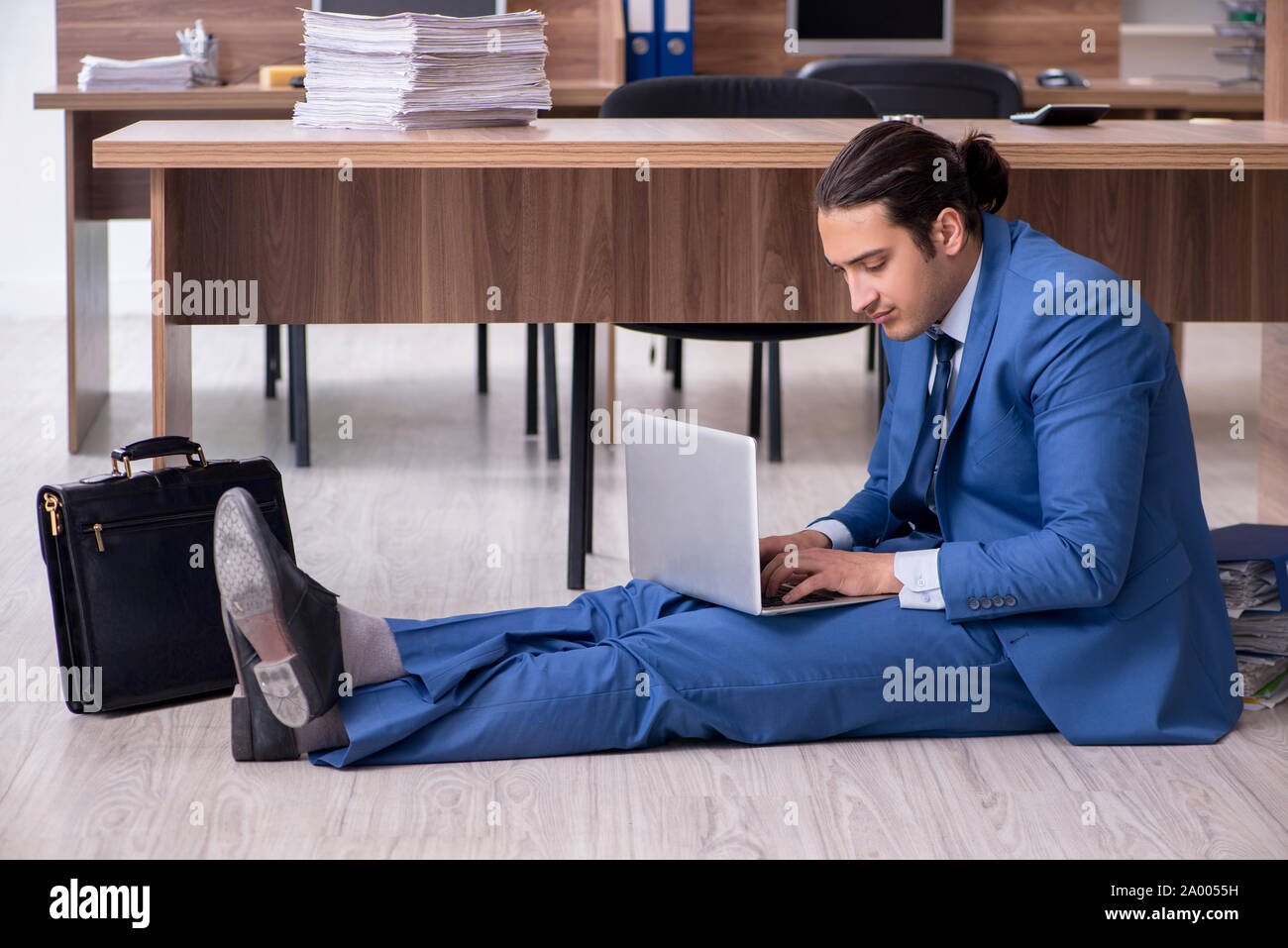 The young male employee and too many work in the office Stock Photo - Alamy