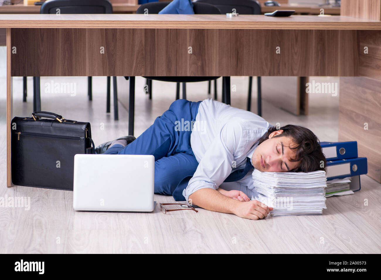The young male employee and too many work in the office Stock Photo - Alamy