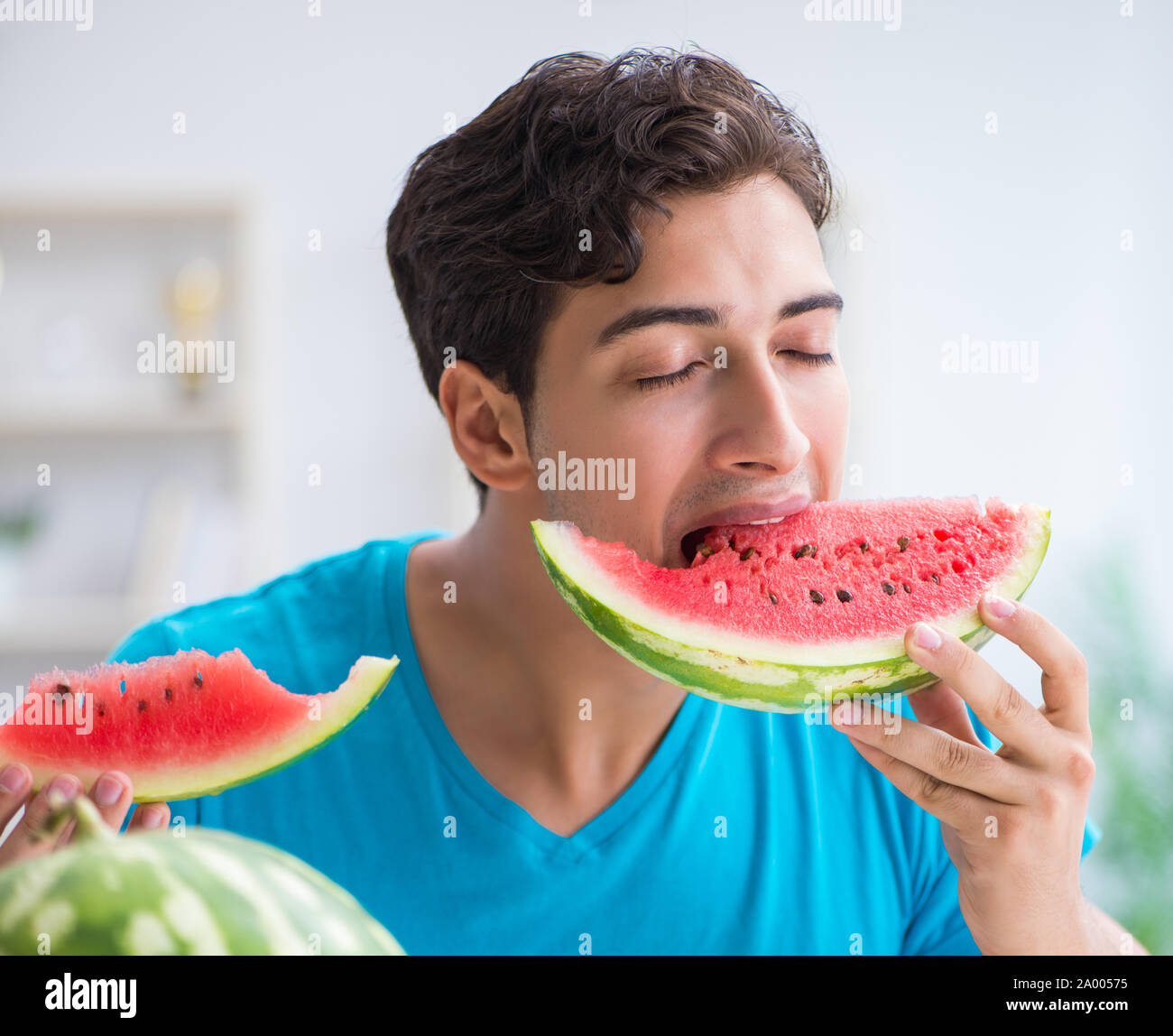The man eating watermelon at home Stock Photo - Alamy