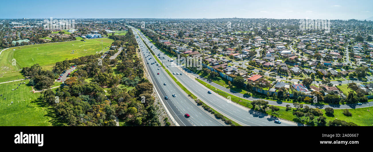 Aerial panorama of highway passing through suburban area on a sunny day ...