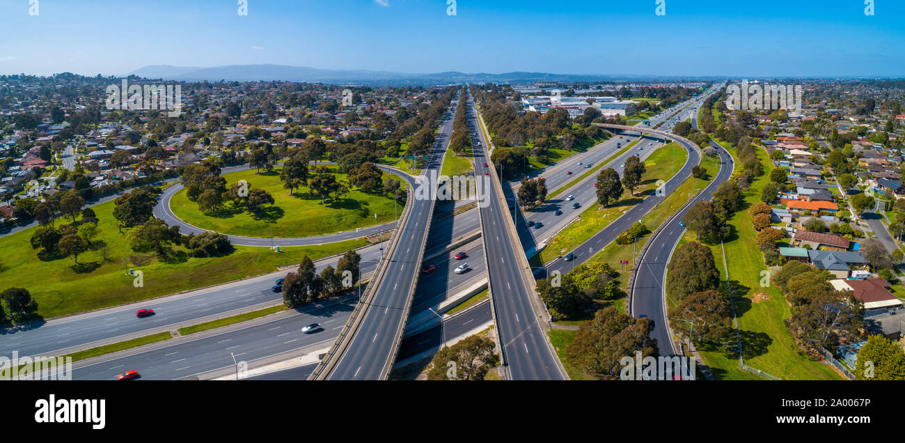 Straight road passing through interchange and leading to mountains in ...