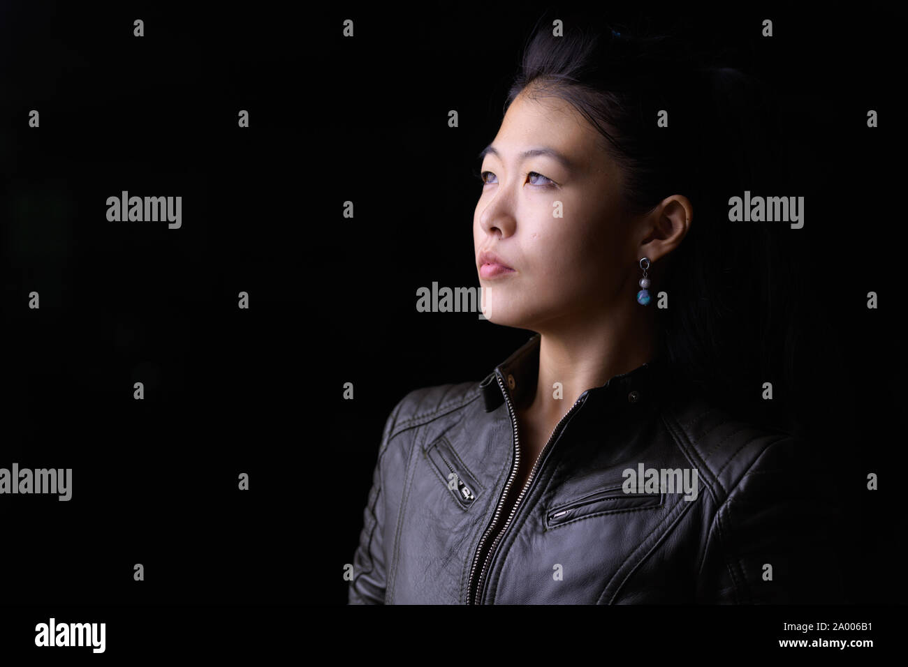 Face of beautiful Asian rebellious woman thinking outdoors at night ...