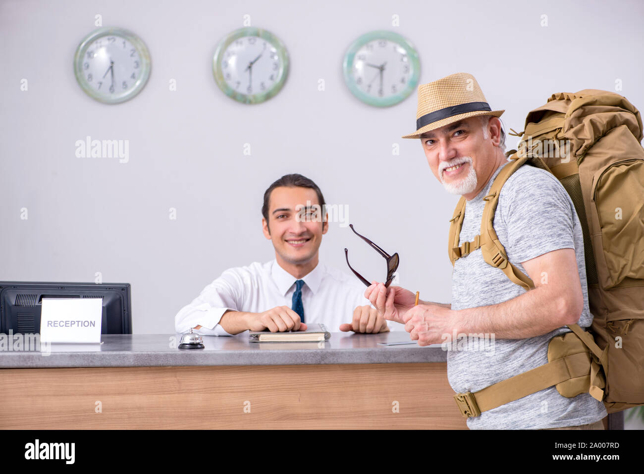 Old backpacker at the hotel reception Stock Photo - Alamy