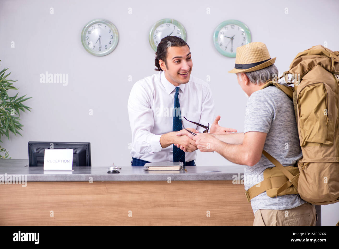 Old backpacker at the hotel reception Stock Photo - Alamy