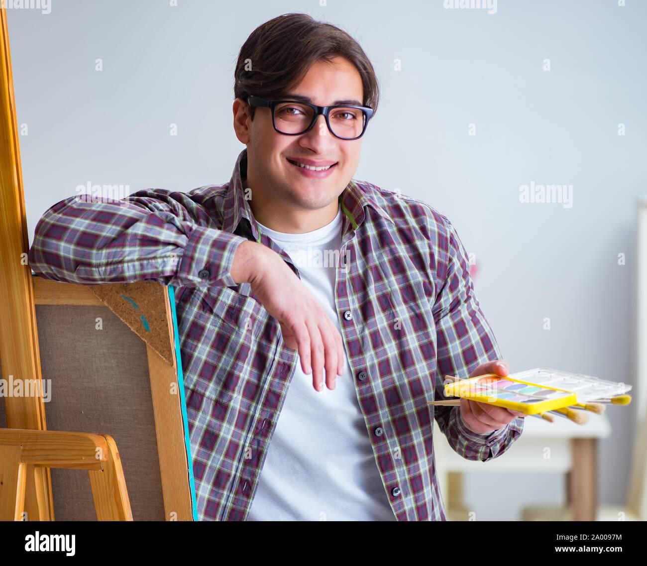 The young male artist drawing pictures in bright studio Stock Photo - Alamy