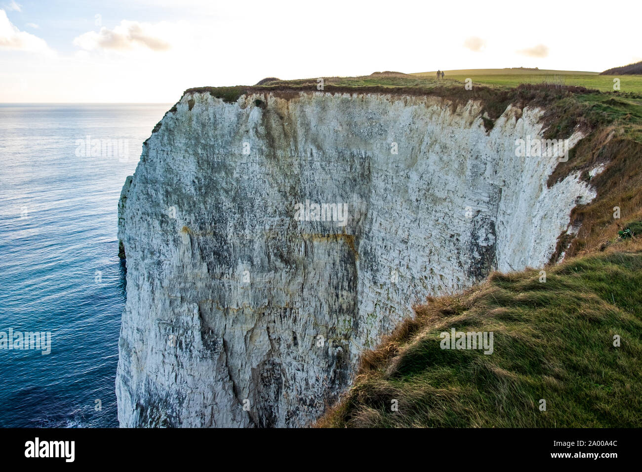 White chalk cliffs with two people in the distance Stock Photo - Alamy