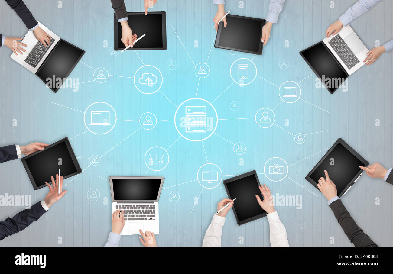 Group of people with devices in hands working in team on tablets ...