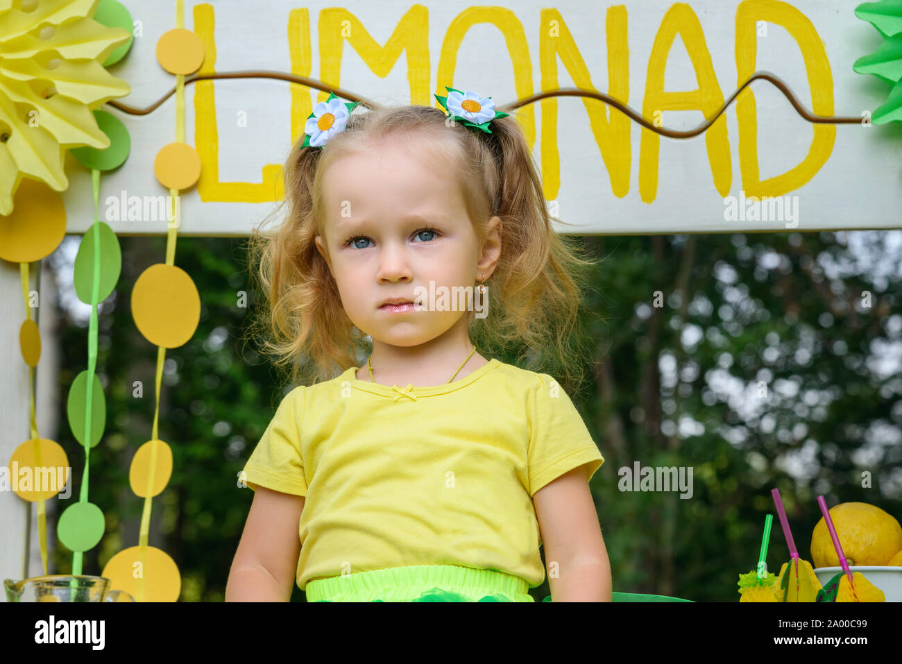 Little girl sitting on lemonade stand in park in summer day Stock Photo ...