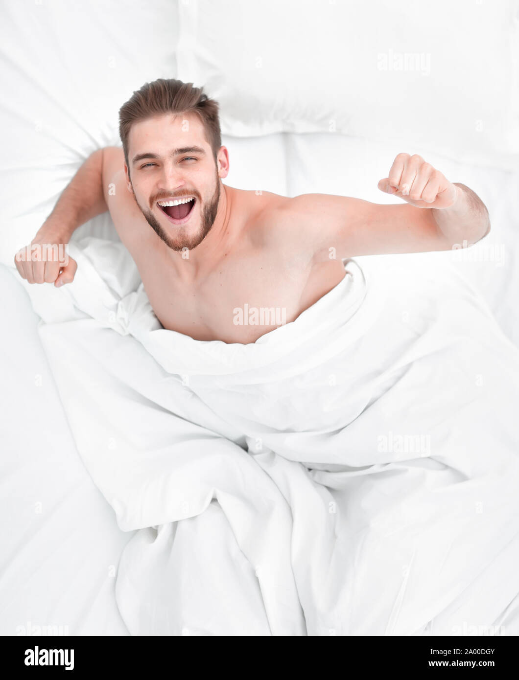 top view. happy man waking up in a comfortable bed Stock Photo - Alamy