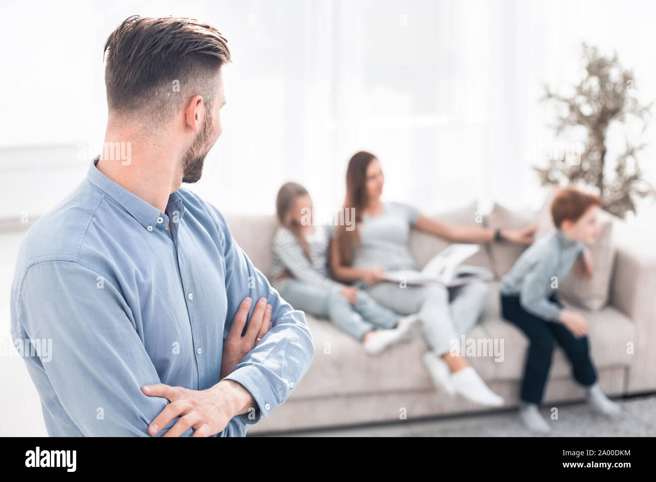 man standing in his living room and looking at his family Stock Photo ...
