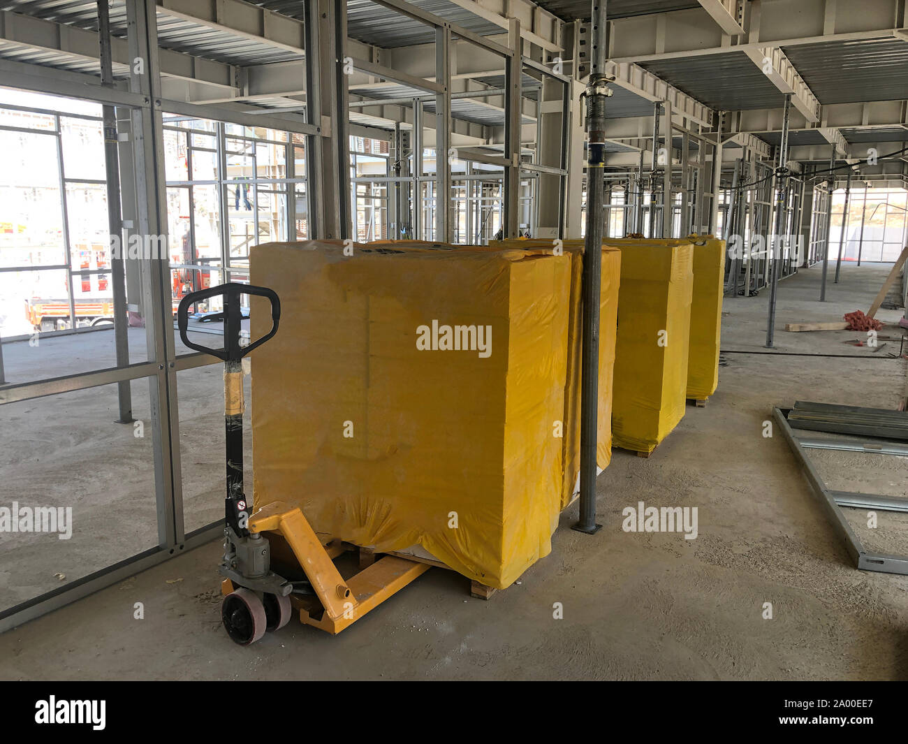 Piled cinder blocks wrapped in yellow packaging on the floor of the ...