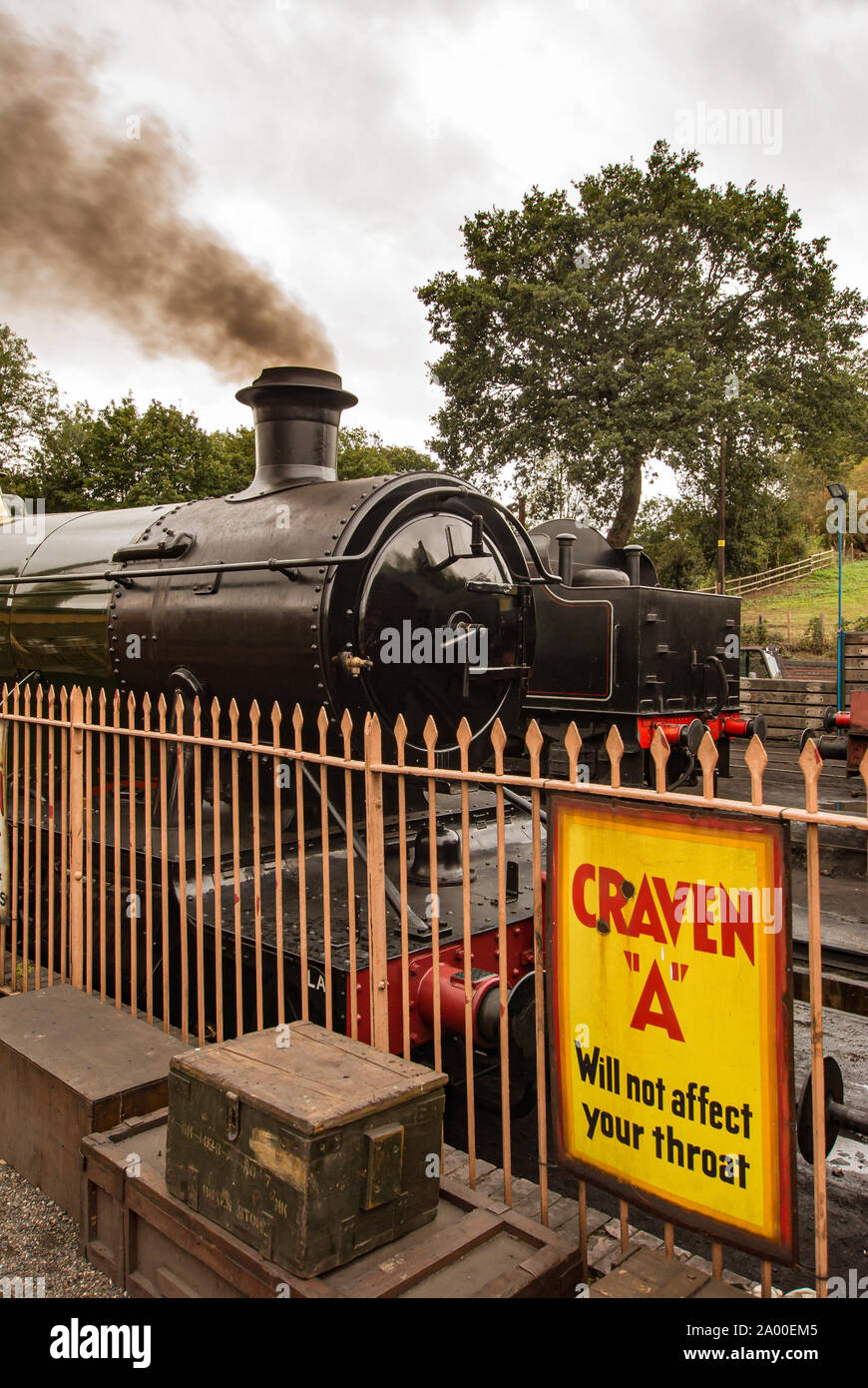 Old cigarette advertisement sign on railings next to railway line with ...