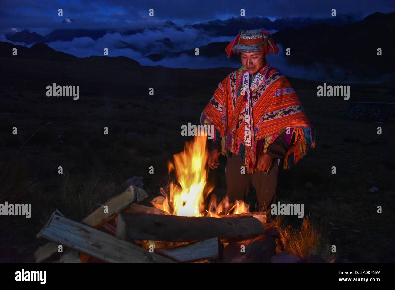 Indio man with hat and colorful traditional poncho standing at a ...