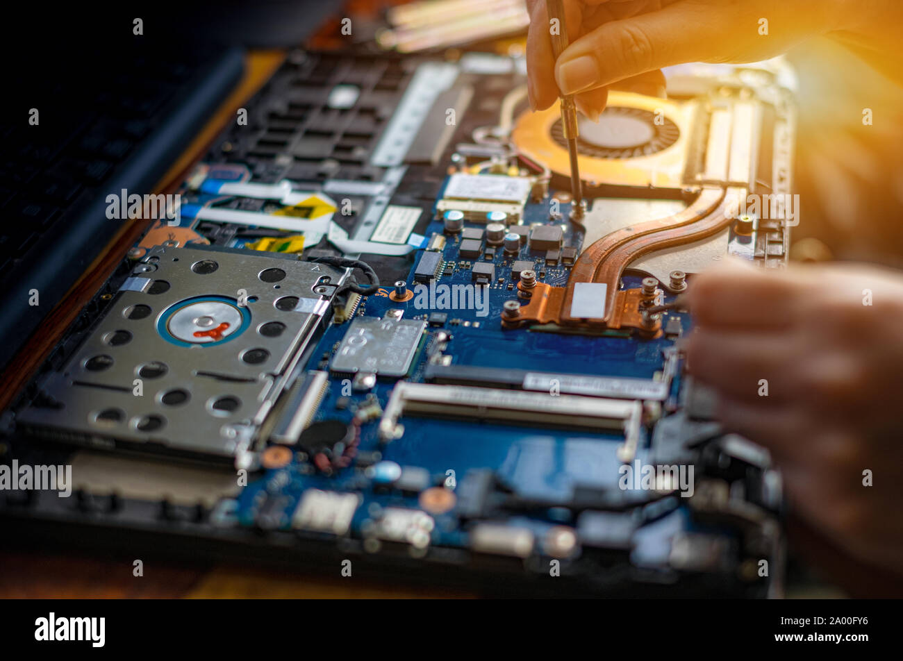 Technician repairing broken laptop notebook computer with screwdriver ...