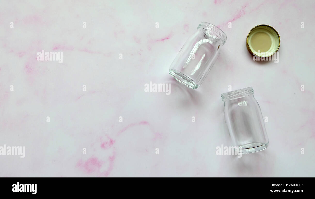 Flat lay of two empty glass bottles and lid, on a pink surface Stock ...