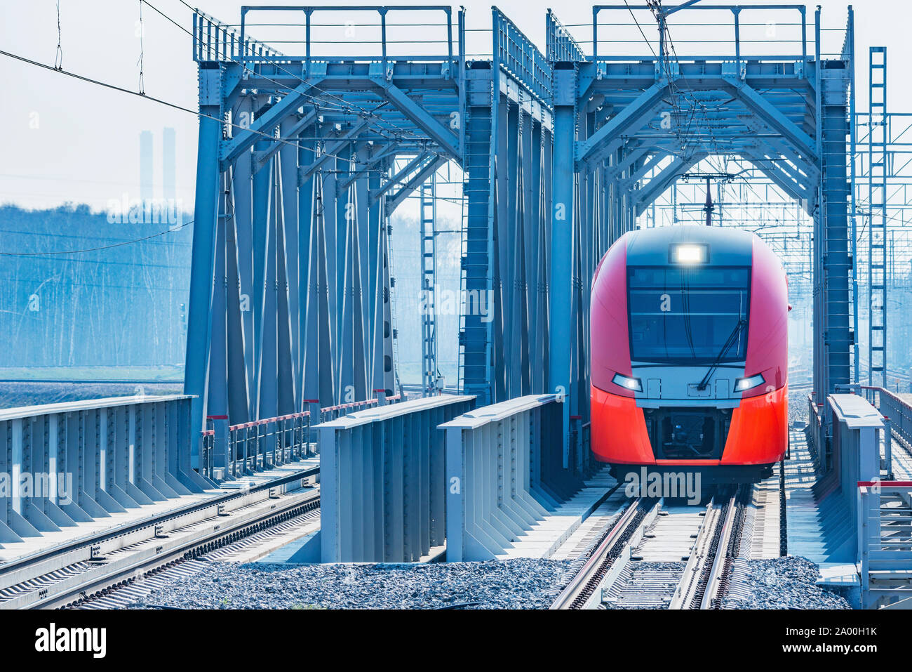 Modern high-speed train moves through the bridge Stock Photo - Alamy