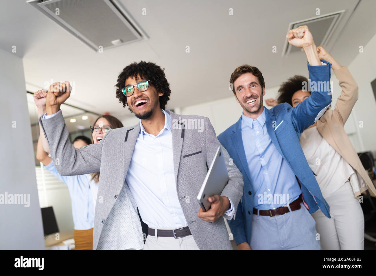 Happy business people celebrating success at company Stock Photo - Alamy