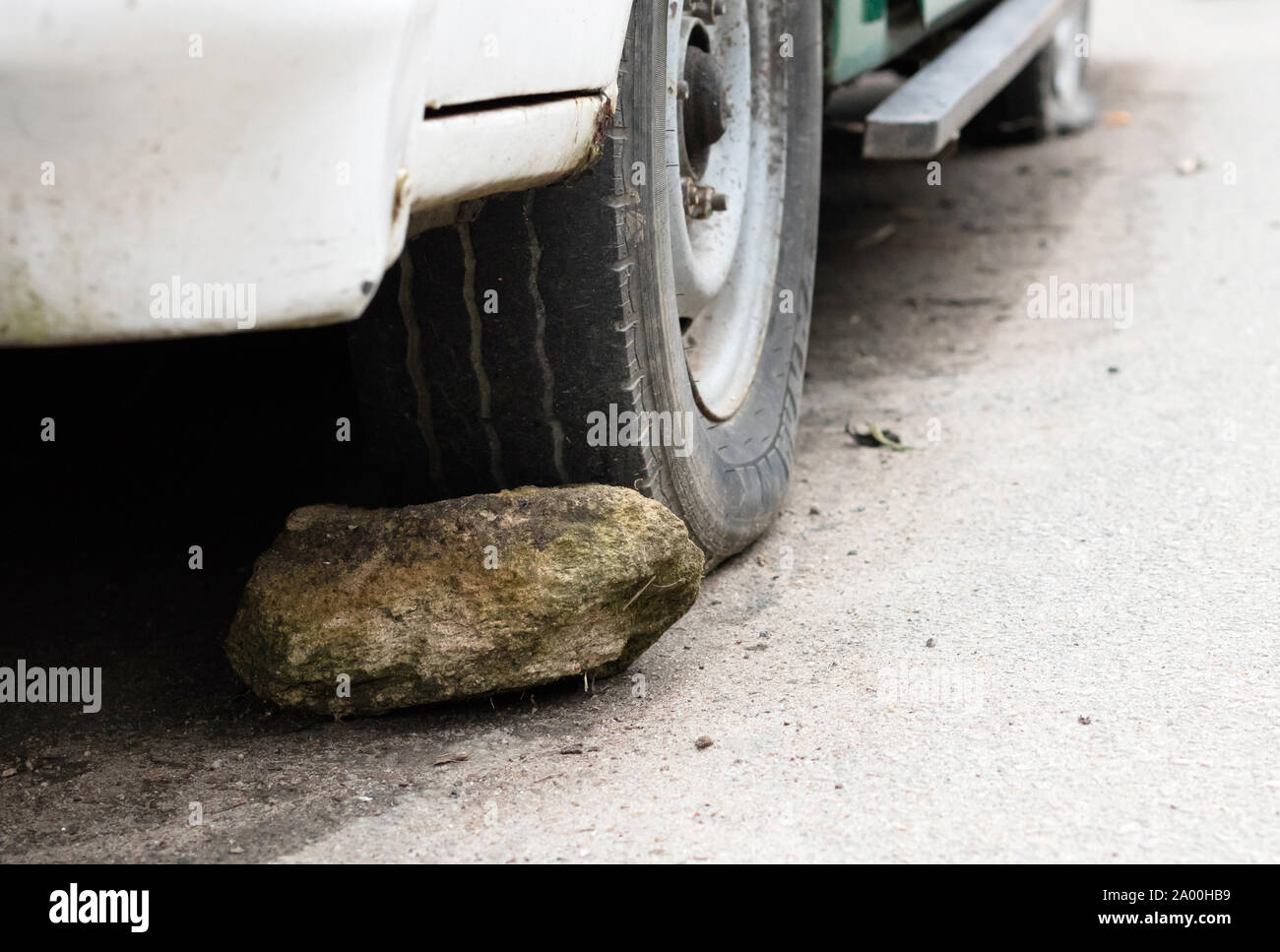 Large stone behind a wheel of a car - No faith in the brakes Stock ...
