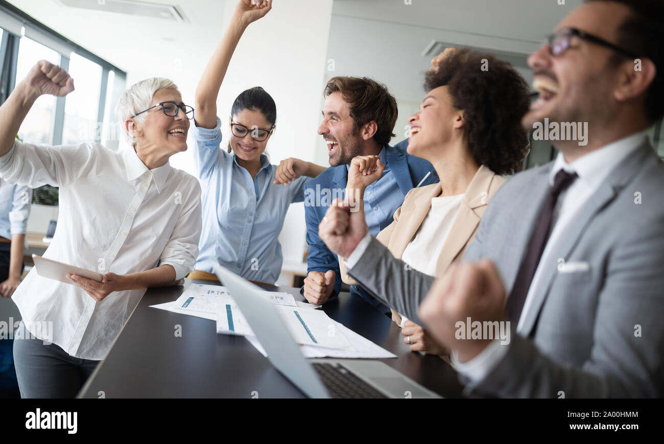 Happy business people celebrating success at company Stock Photo - Alamy