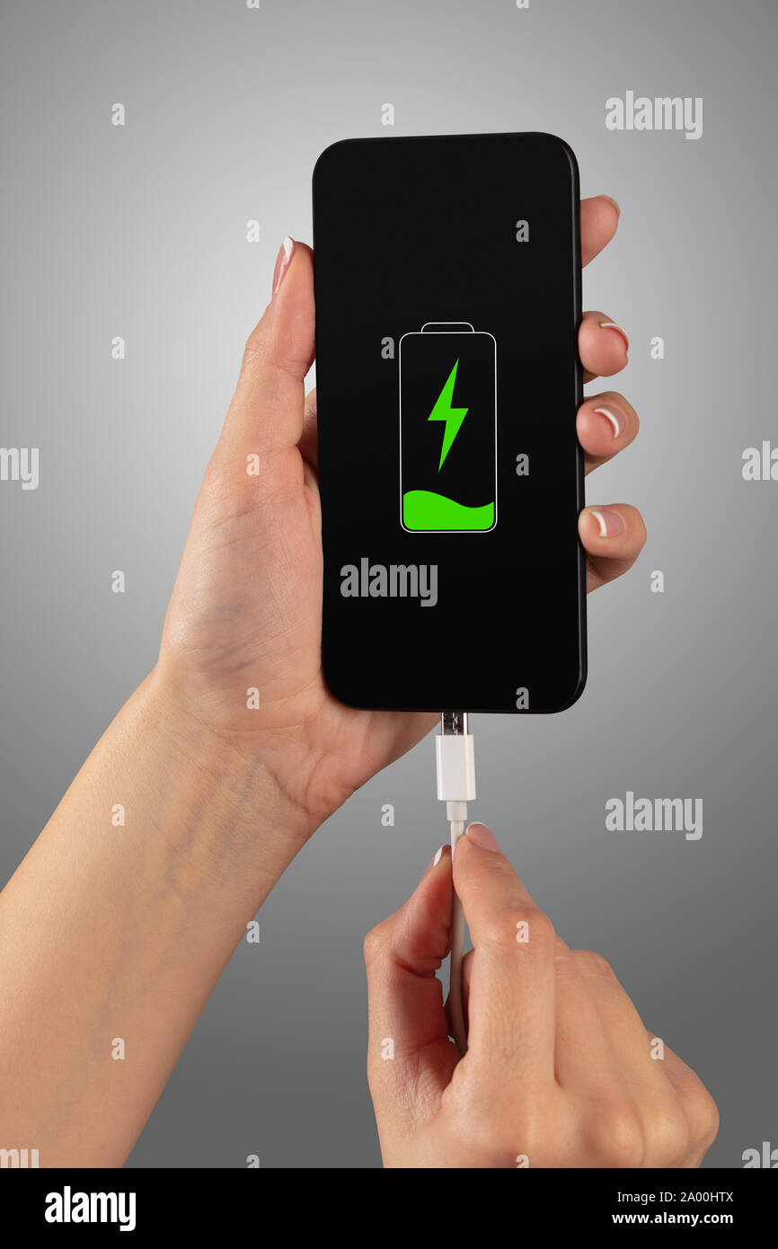 Elegant hand charging cellphone with low battery Stock Photo - Alamy