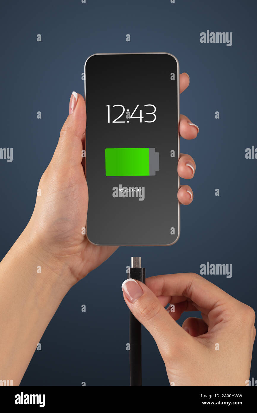 Elegant hand charging smartphone with low battery Stock Photo - Alamy