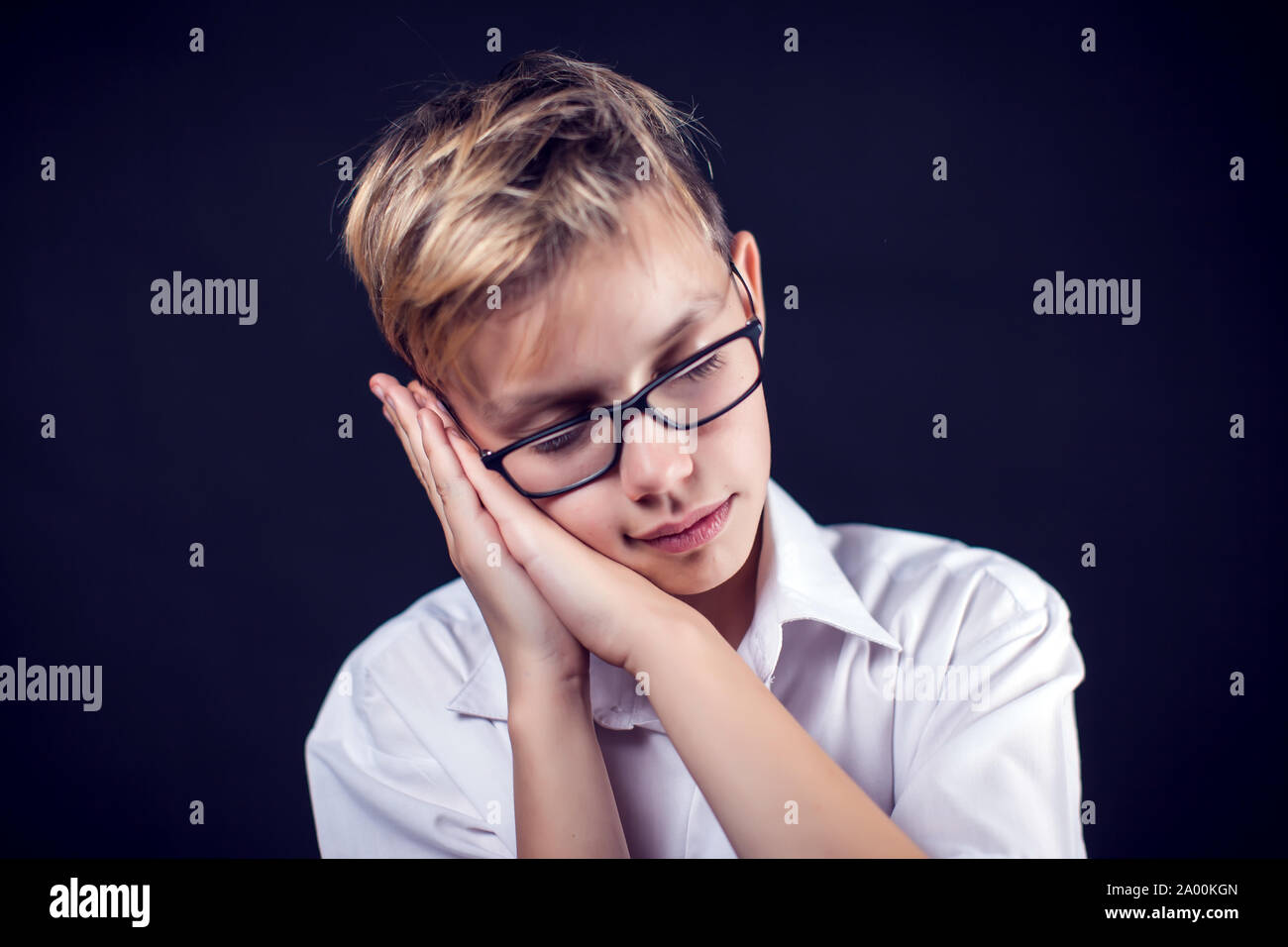 Tired boy teenager shows sleeping gesture. People and emotion concept ...