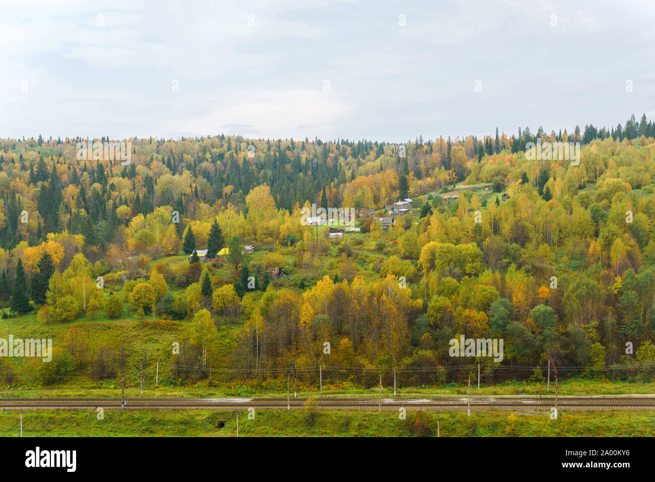landscape autumn river valley with a village between wooded hills and ...
