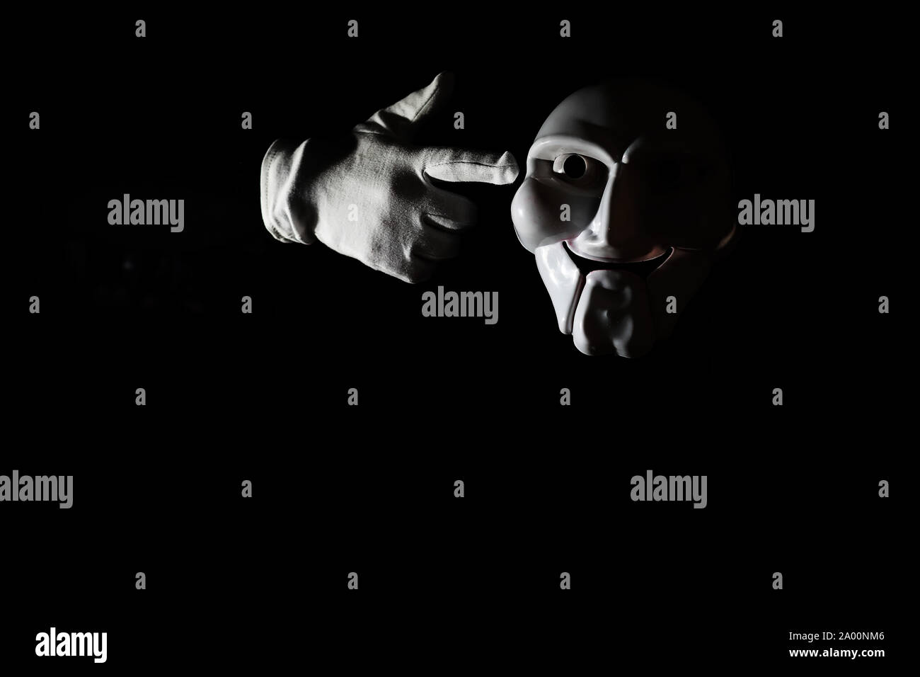 White scary mask on a black background with whites hand Stock Photo - Alamy