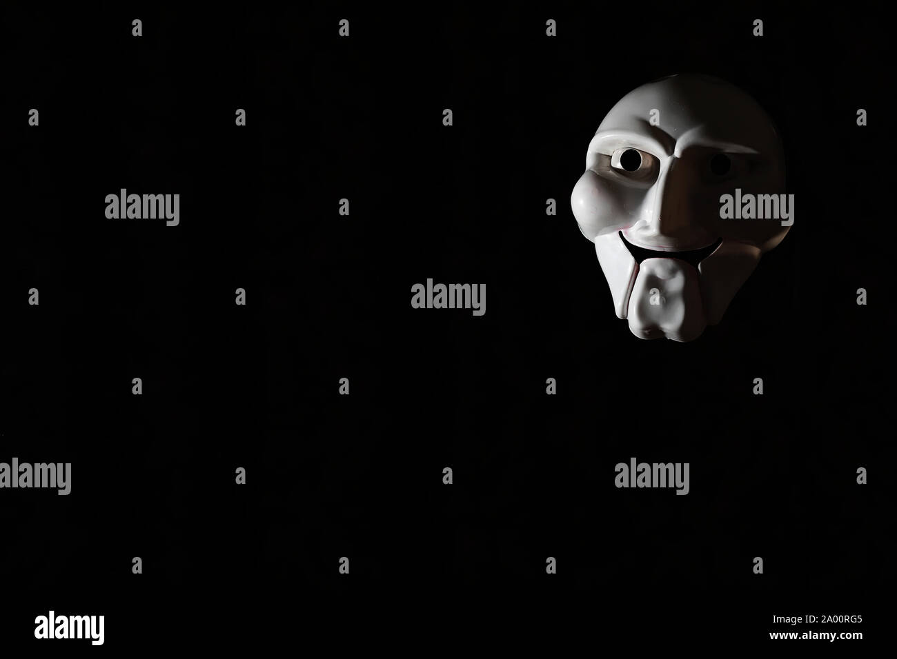 White scary mask on a black background with whites hand Stock Photo - Alamy