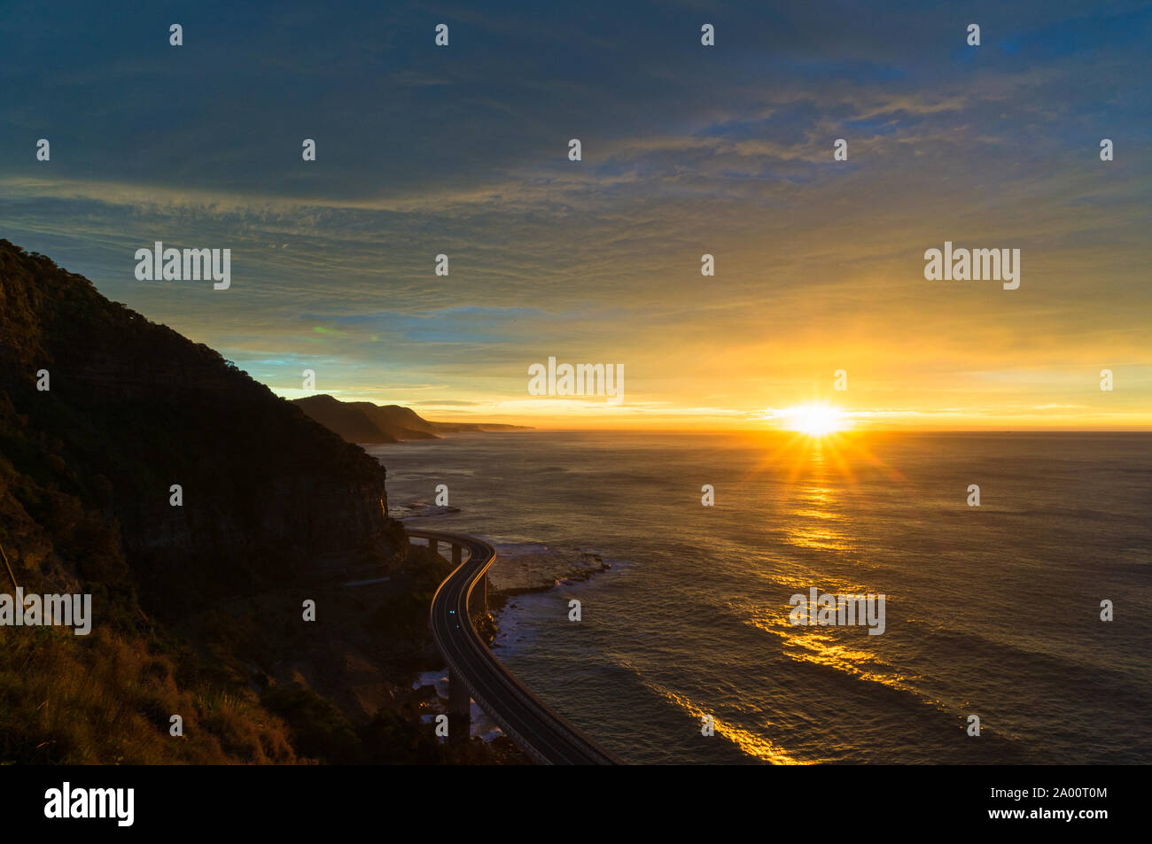Sea cliff bridge along Australian Pacific ocean coast on sunrise. Sun ...