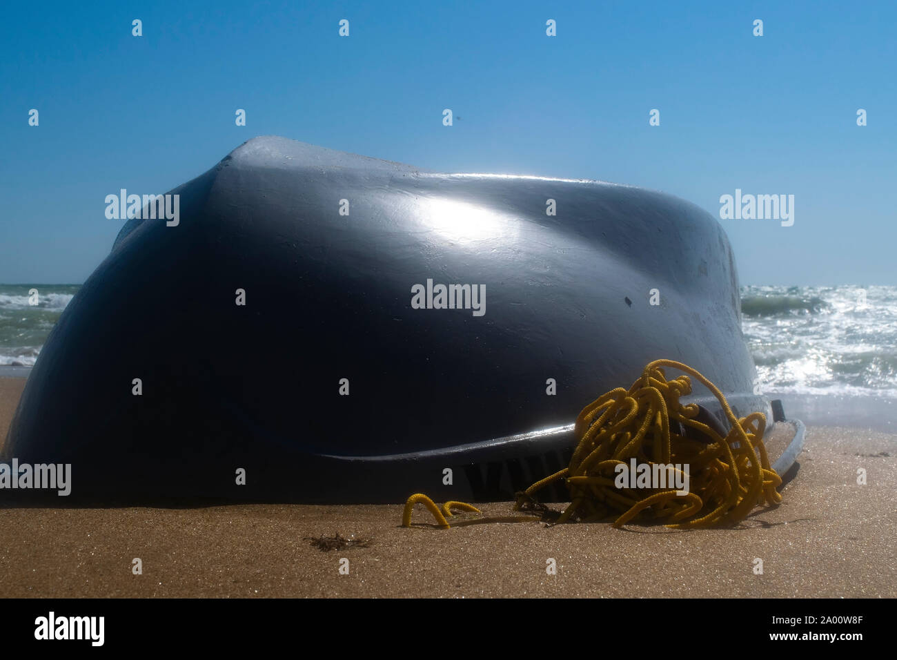 Overturned boat on the sandy beach. Sunny weather and small waves Stock ...