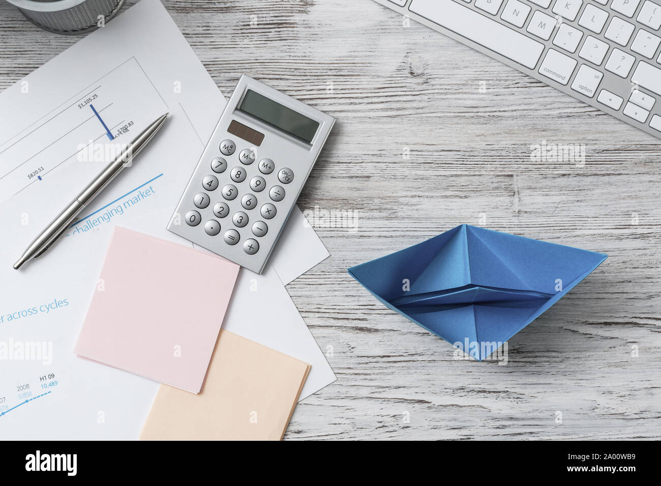 Modern office workspace with blue paper ship. Corporate strategy and ...