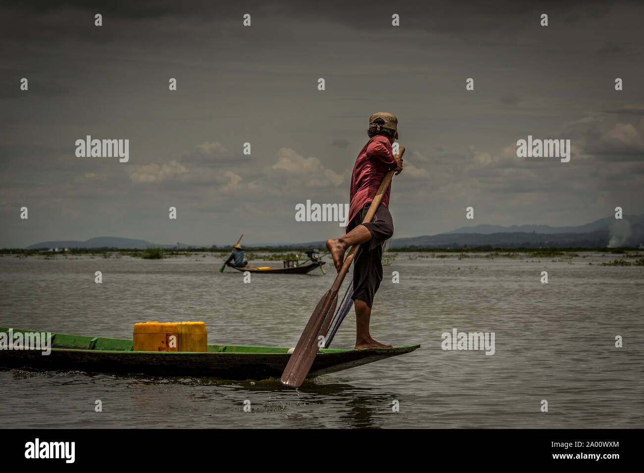 Fisher in balance on small boat Stock Photo - Alamy