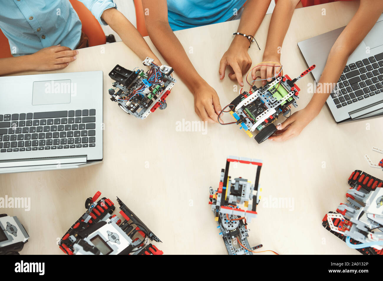 Robotics. Children sitting having class working on robots using laptop ...