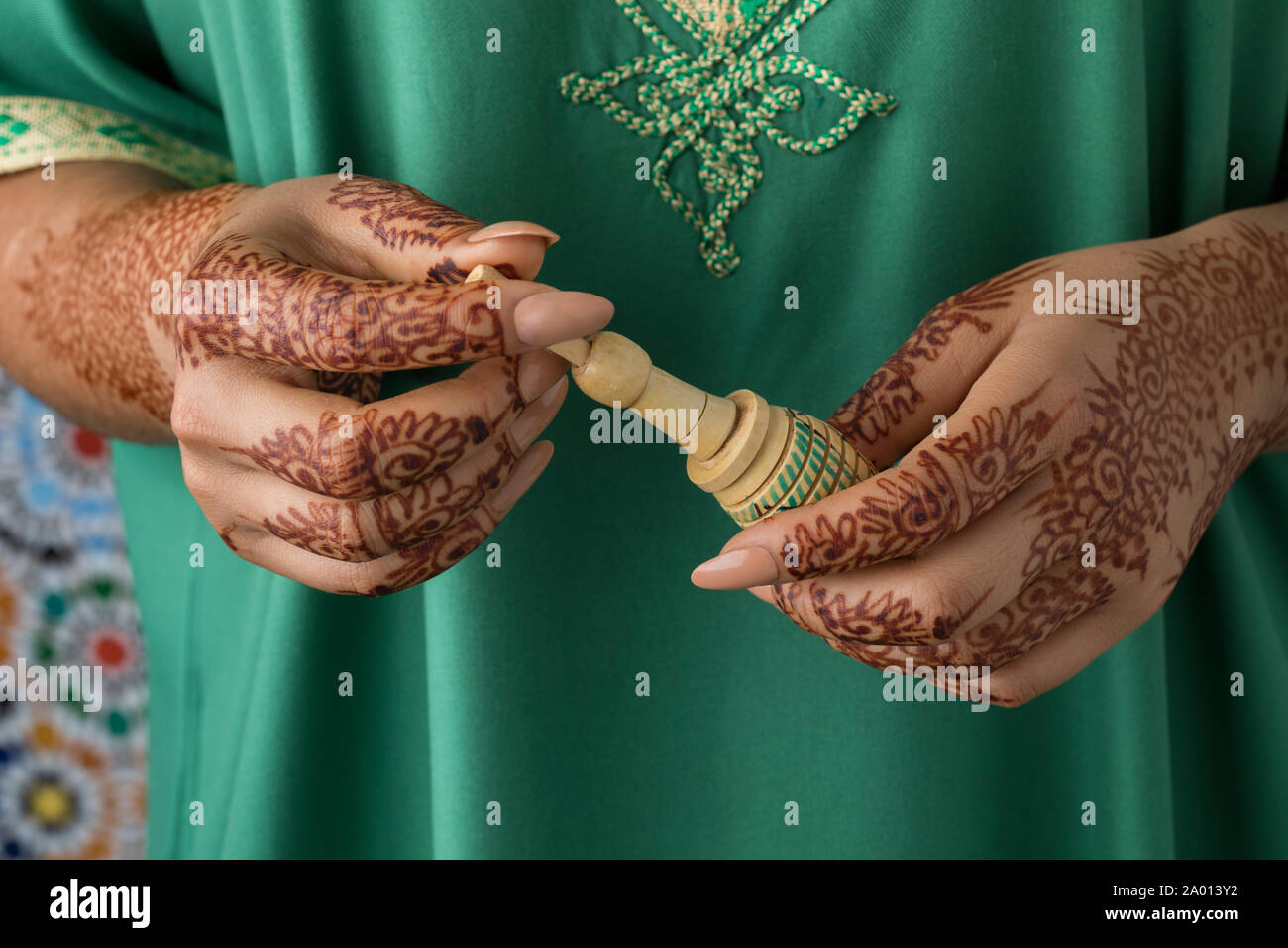 Moroccan woman with traditional henna painted hands holding a wooden ...