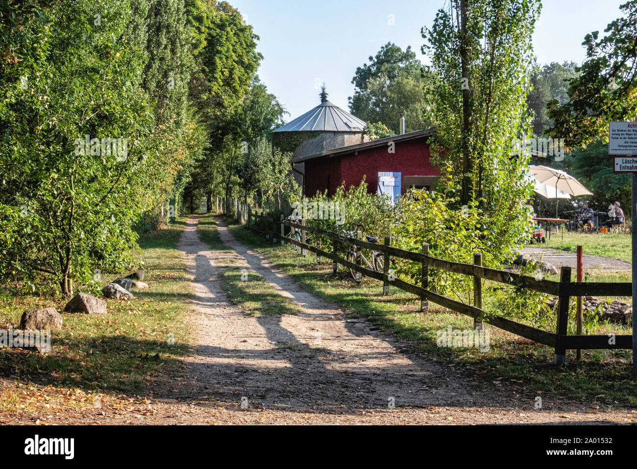 Rural dirt road, Red building of community centure and old farm storage ...