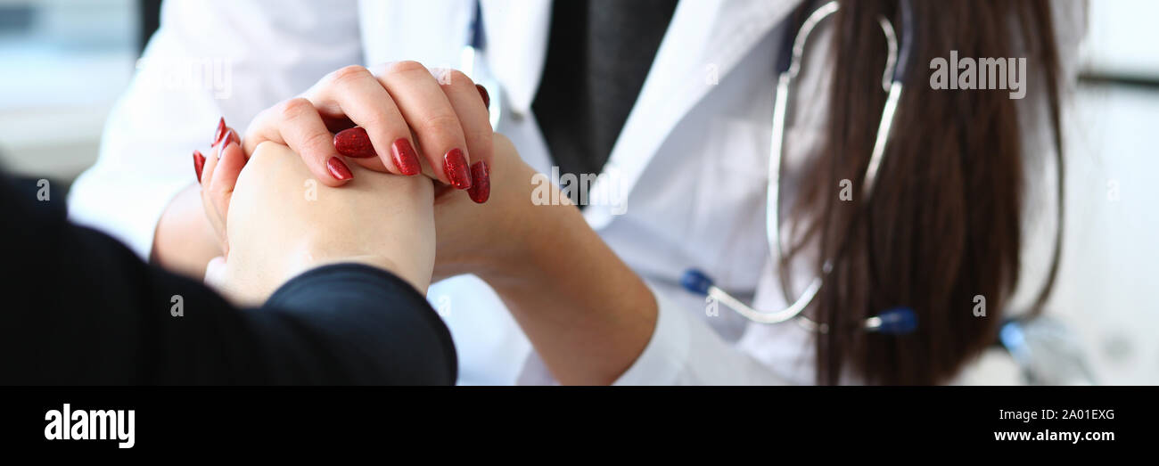 Young female doctor holds sick patient by hand Stock Photo - Alamy