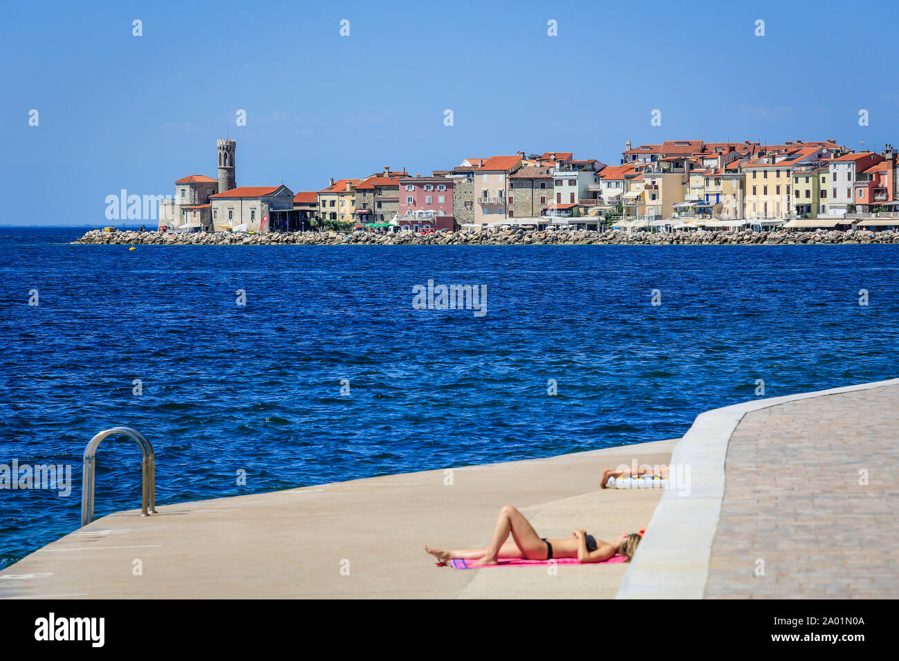 Piran, Istria, Slovenia - Bathers at the concrete beach Fornace of the port town Piran at the ...