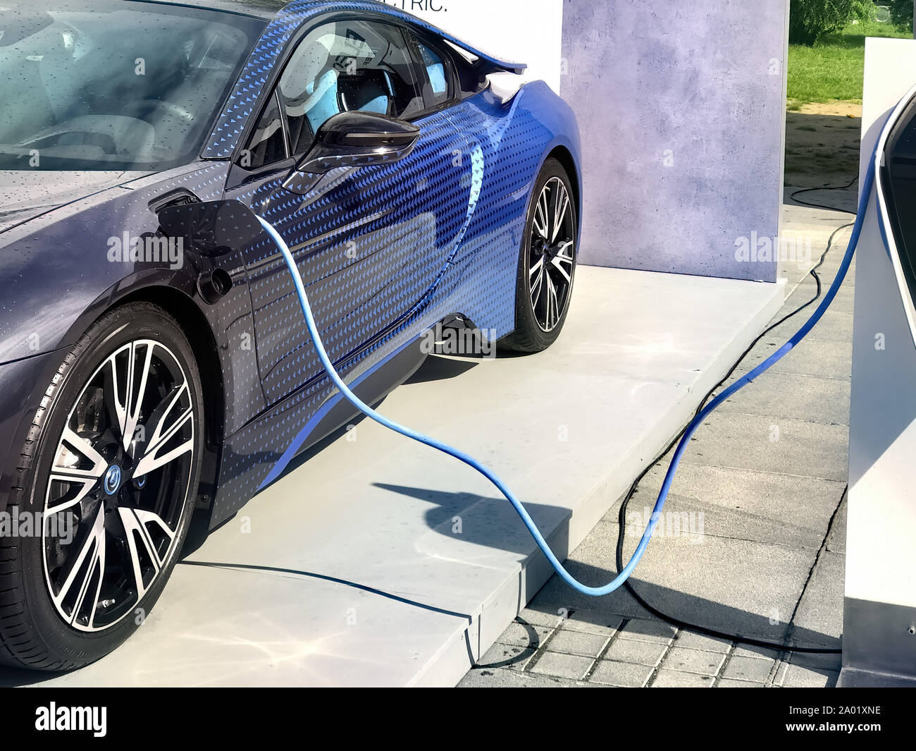 Electric vehicle being plugged in Stock Photo - Alamy